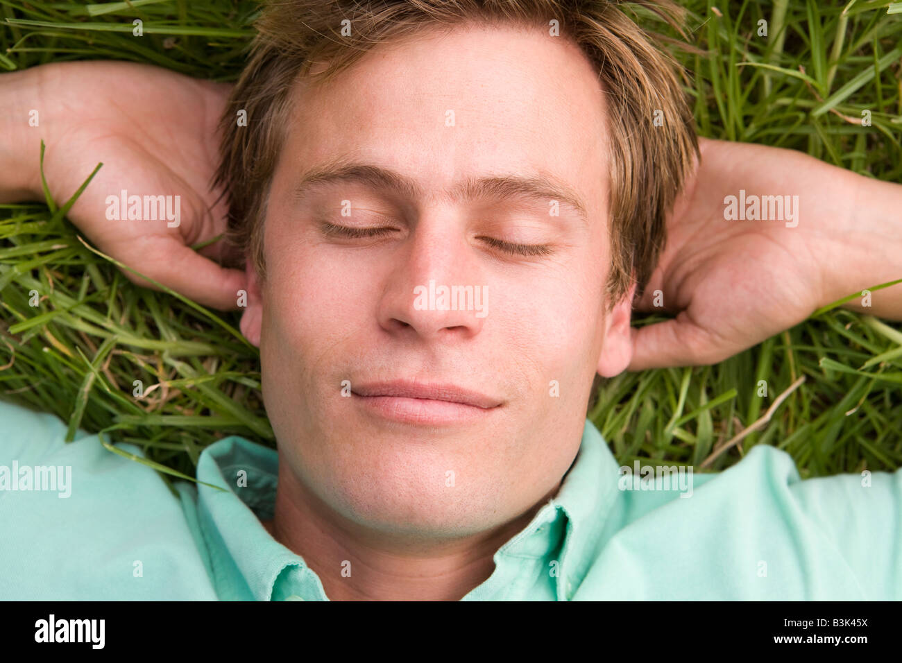 Man lying on grass sleeping Stock Photo - Alamy