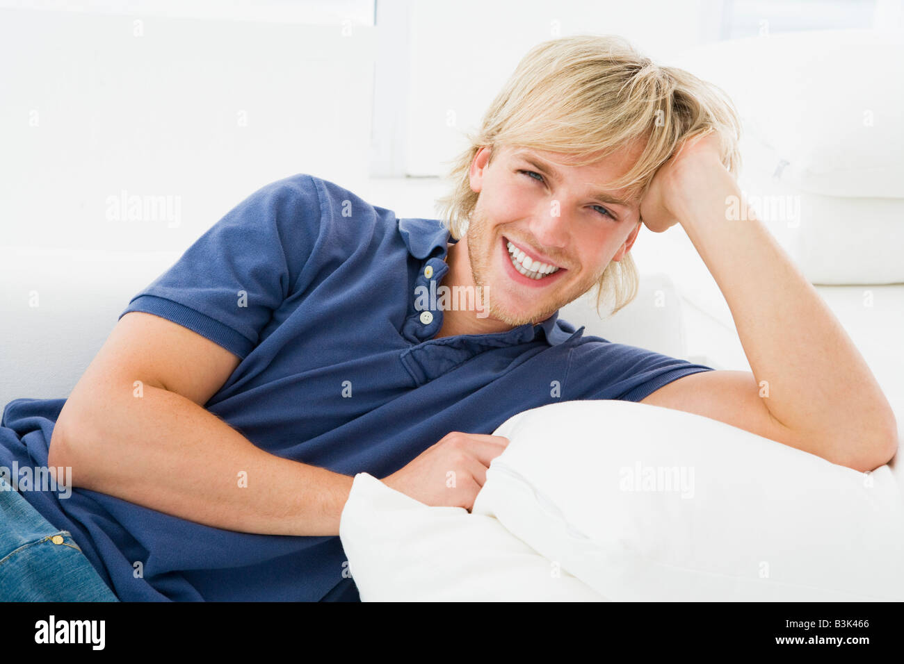 Man sitting in living room smiling Stock Photo - Alamy