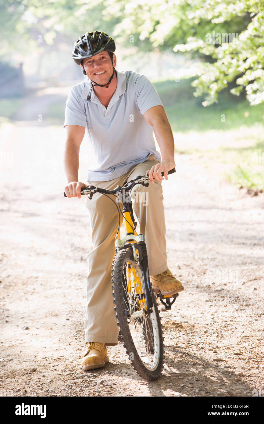 Man outdoors on bike smiling Stock Photo - Alamy