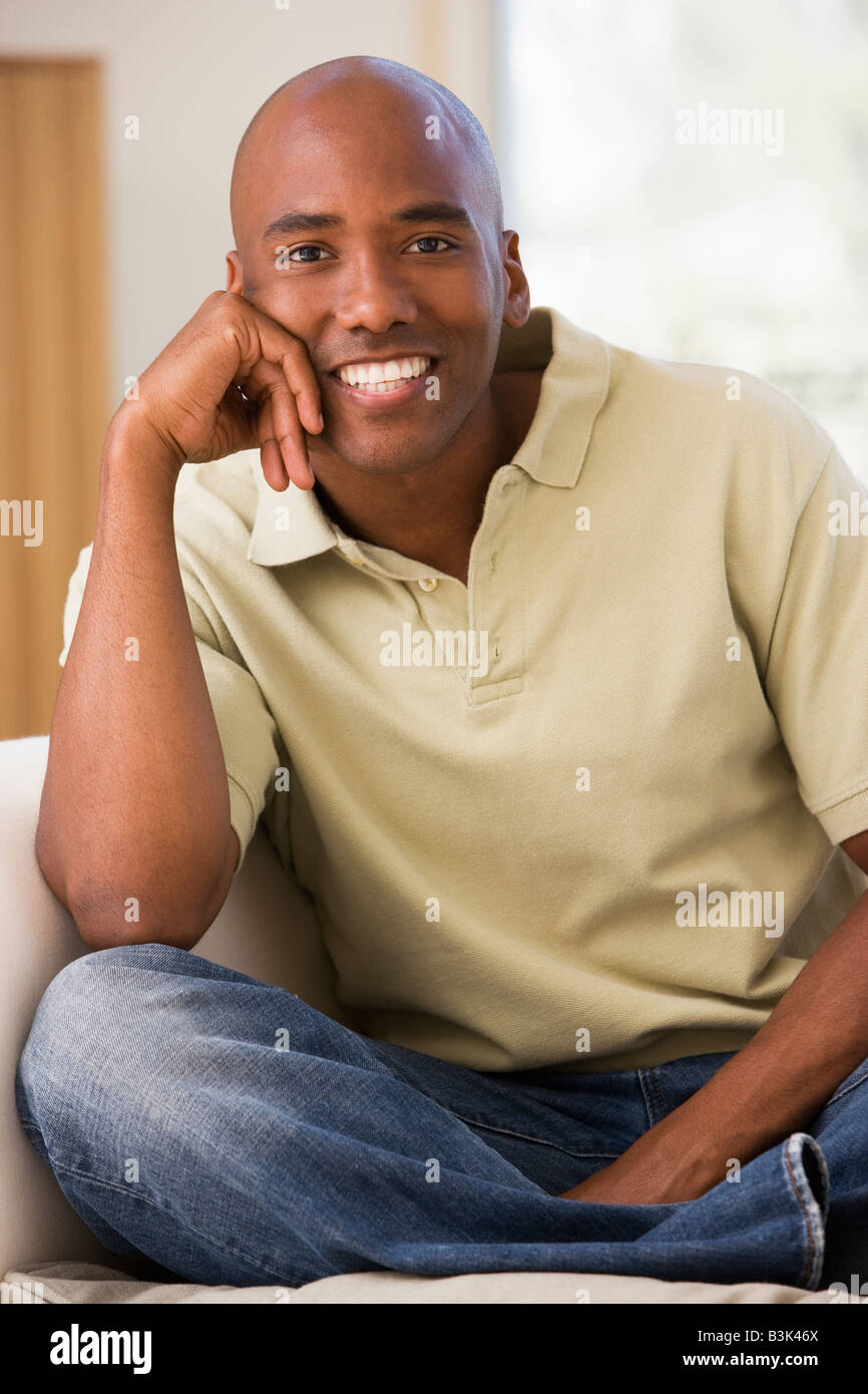 Man sitting in living room smiling Stock Photo - Alamy