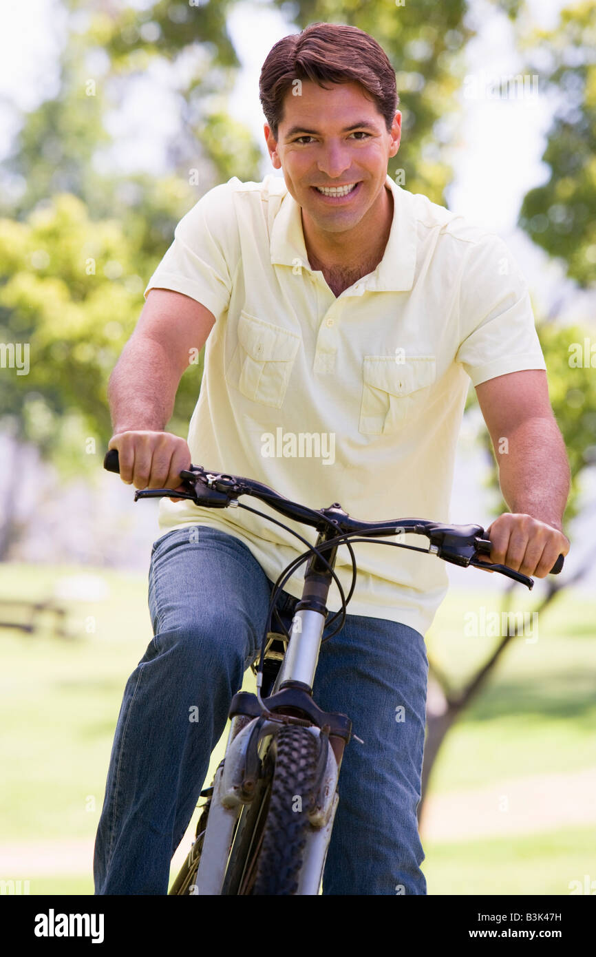 Man outdoors on bike smiling Stock Photo - Alamy