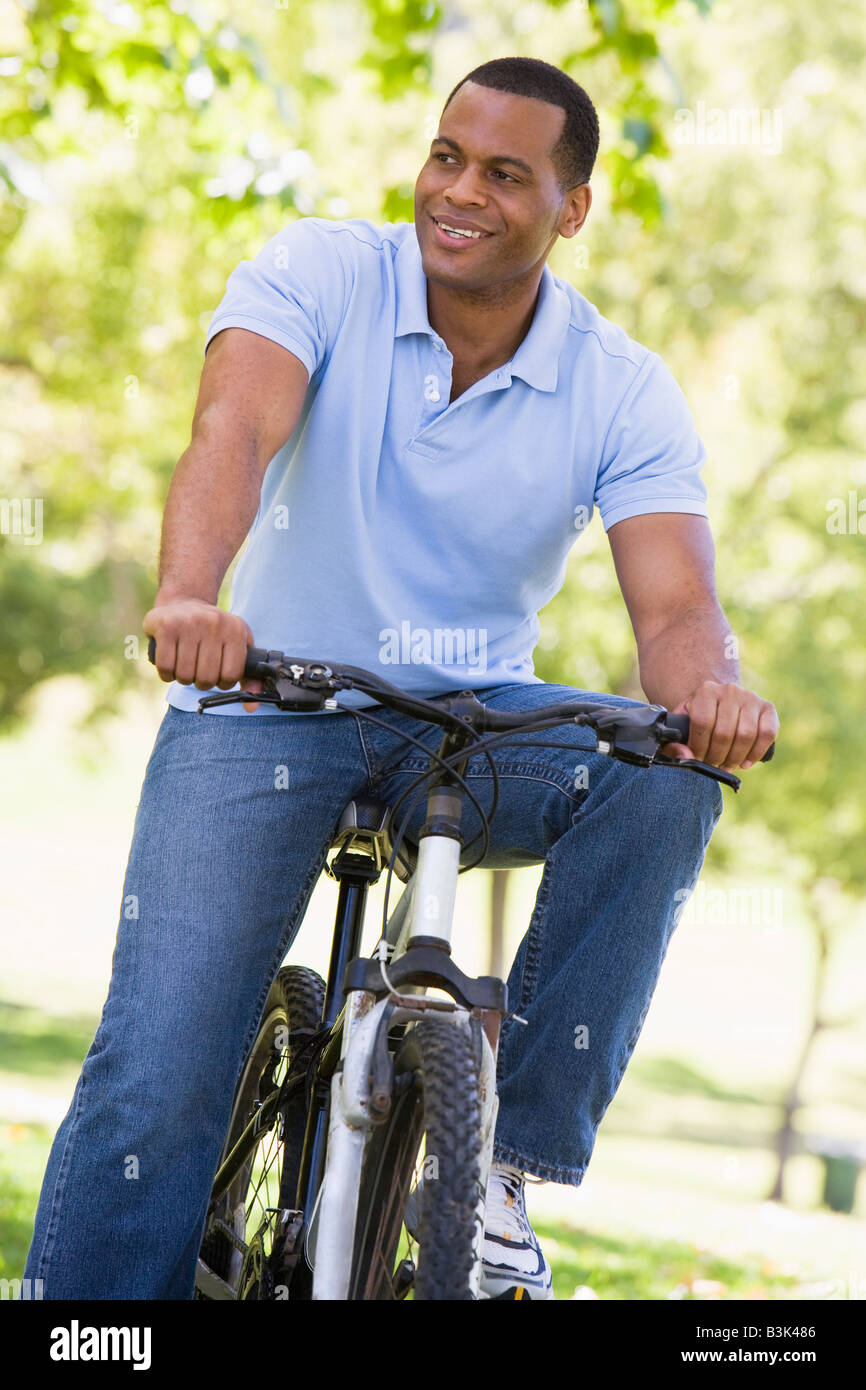 Man outdoors on bike smiling Stock Photo - Alamy