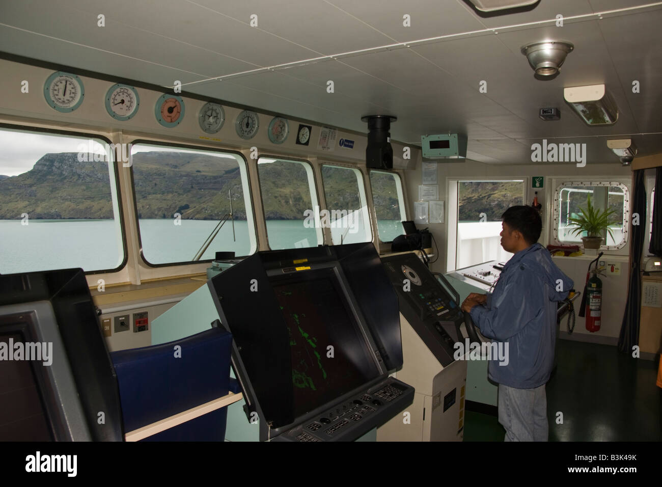 Helmsman at the wheel of a ship aarriving in port Stock Photo - Alamy