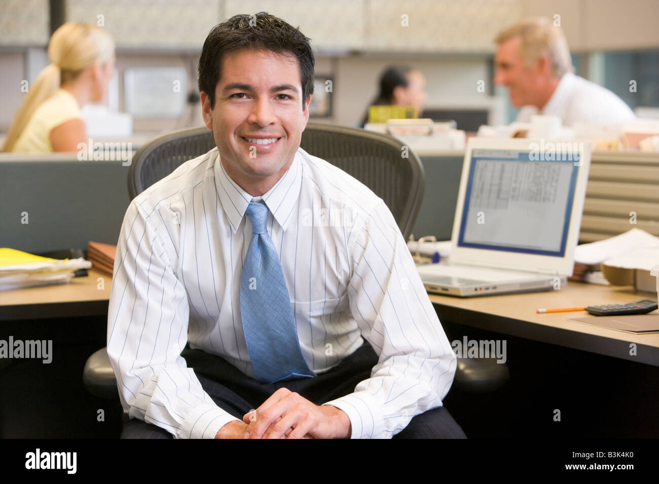 Businessman in cubicle smiling Stock Photo - Alamy