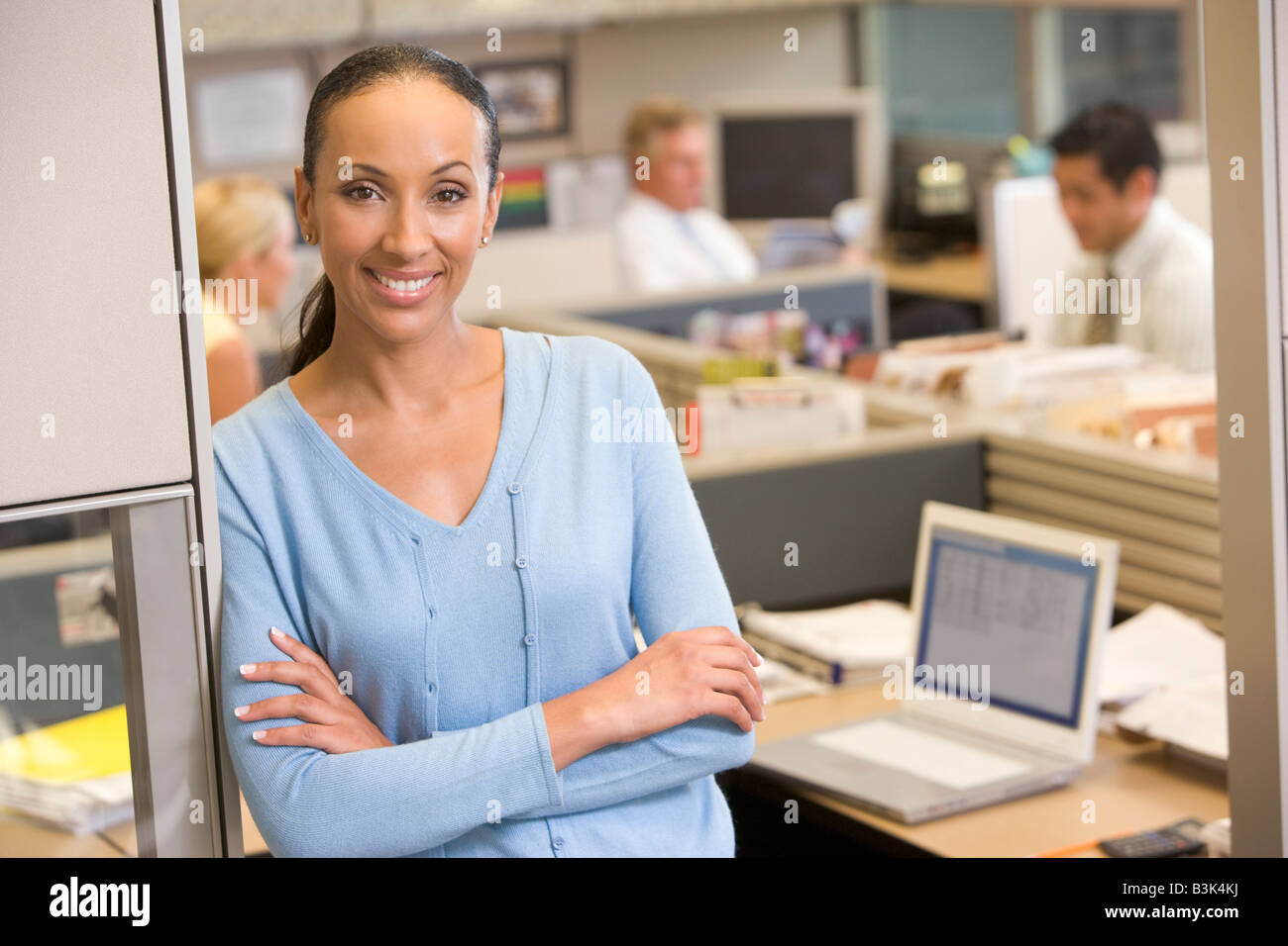 Businesswoman standing in cubicle smiling Stock Photo - Alamy