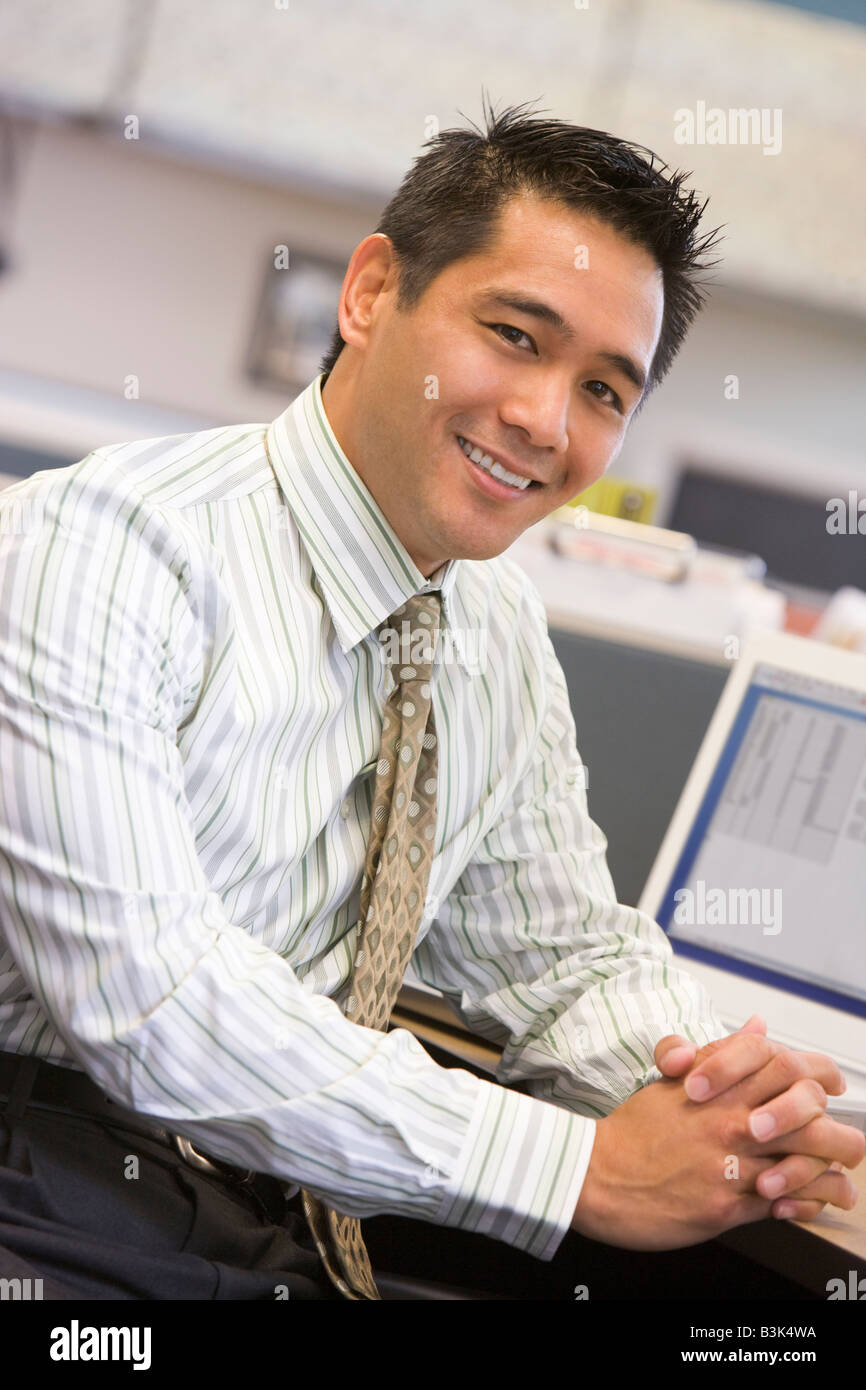 Businessman in cubicle smiling Stock Photo - Alamy