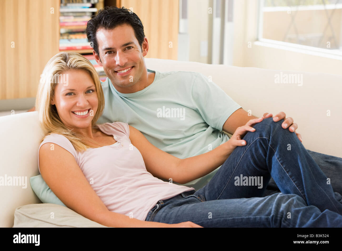 Couple in living room smiling Stock Photo - Alamy
