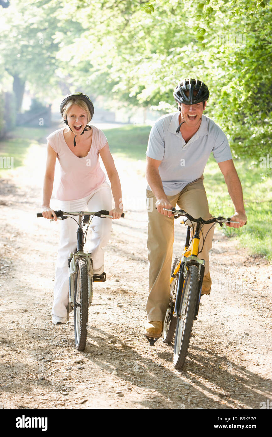 Couple on bikes outdoors smiling Stock Photo - Alamy
