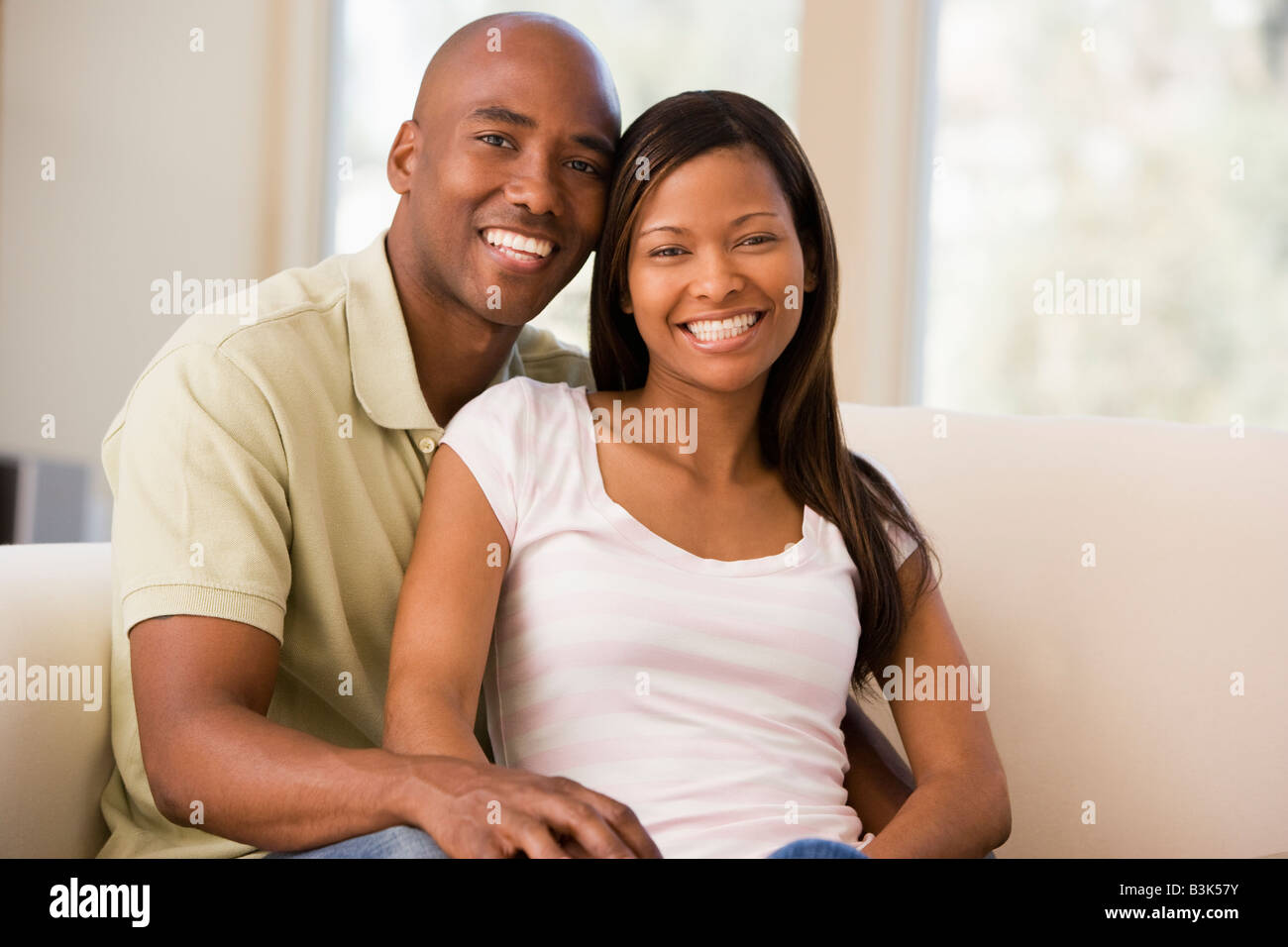 Couple in living room smiling Stock Photo - Alamy