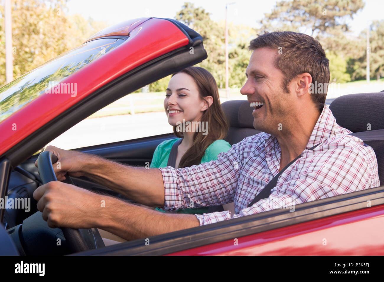 Couple in convertible car smiling Stock Photo - Alamy