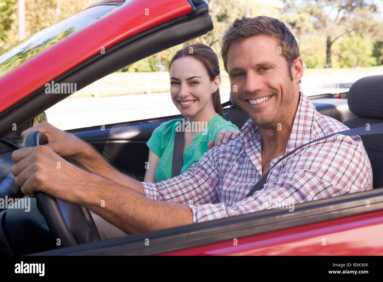 Couple in convertible car smiling Stock Photo - Alamy