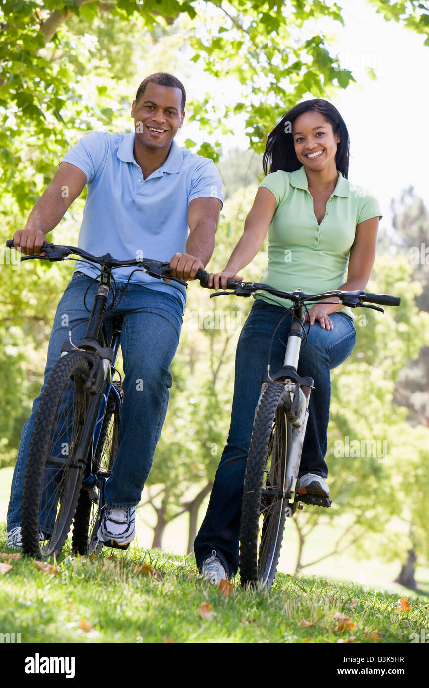 Couple on bikes outdoors smiling Stock Photo - Alamy