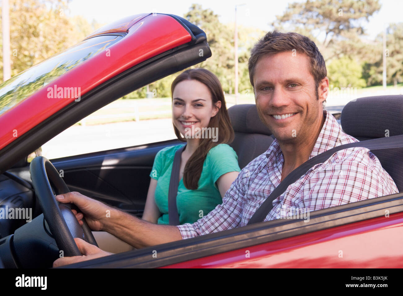 Couple in convertible car smiling Stock Photo - Alamy