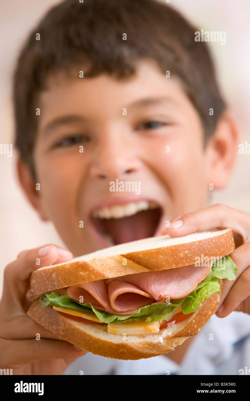 Young boy eating sandwich smiling Stock Photo - Alamy