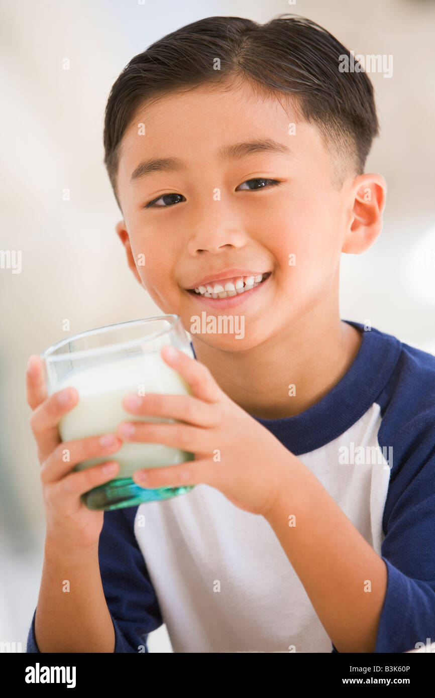 Young boy indoors drinking milk smiling Stock Photo - Alamy