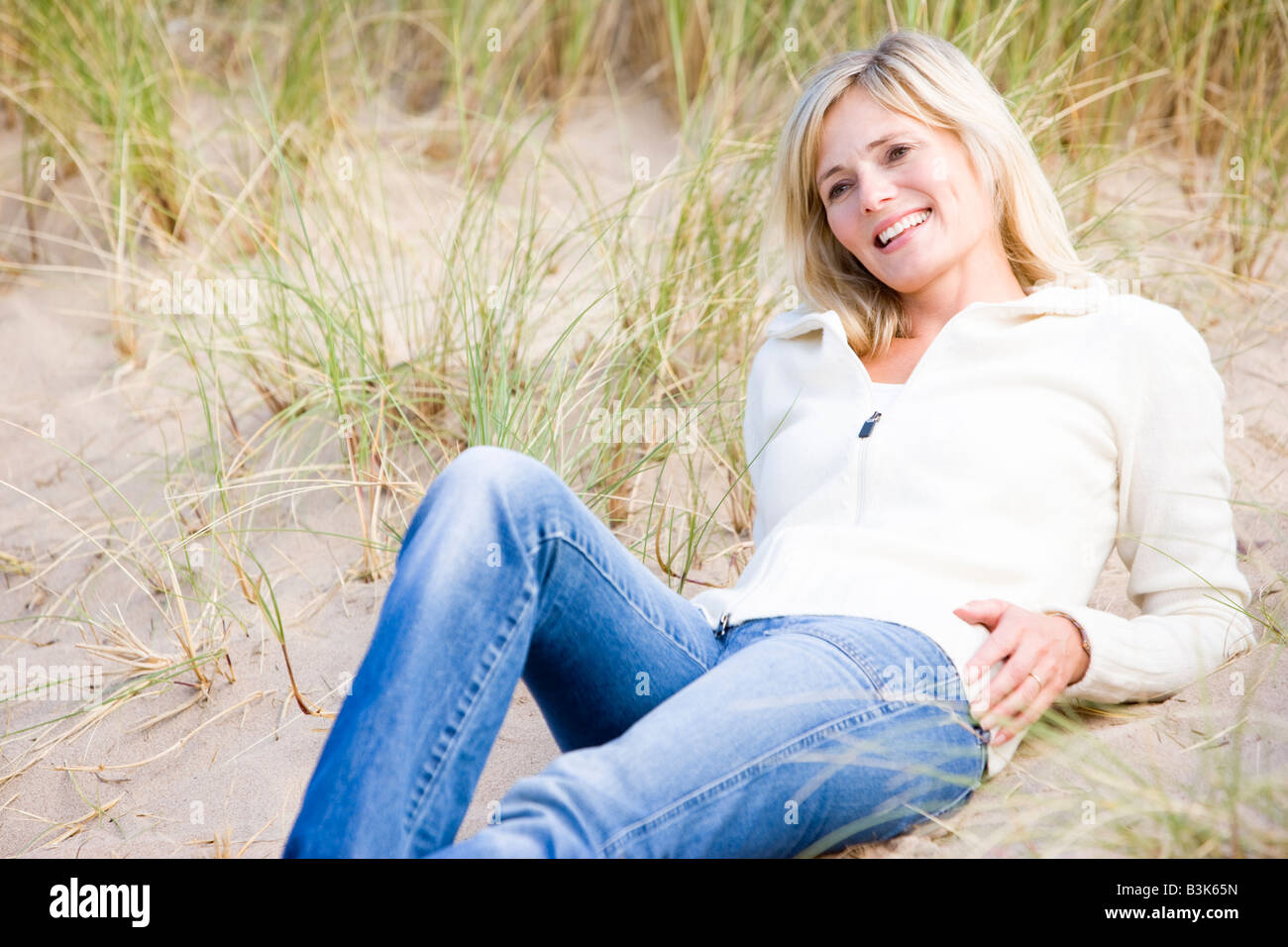 Laying lying down sitting on the beach sand hi-res stock photography ...