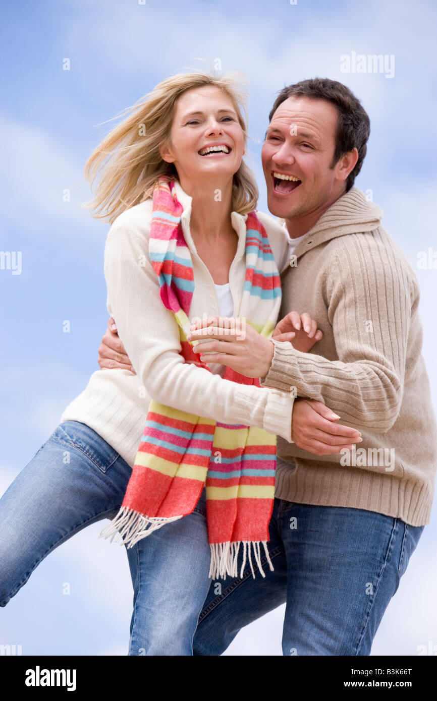 Couple standing cuddling beach hi-res stock photography and images - Alamy