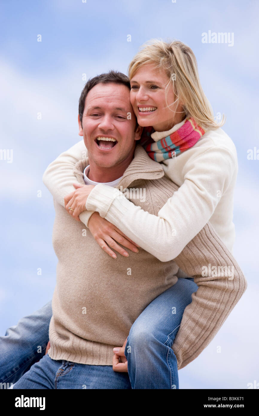 man giving woman piggyback ride outdoors smiling Stock Photo - Alamy