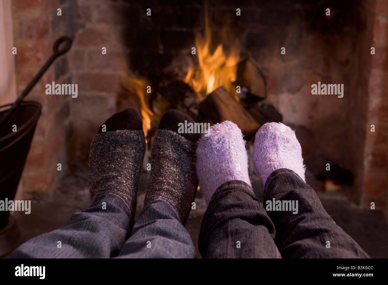 Couple's feet warming at a fireplace Stock Photo - Alamy