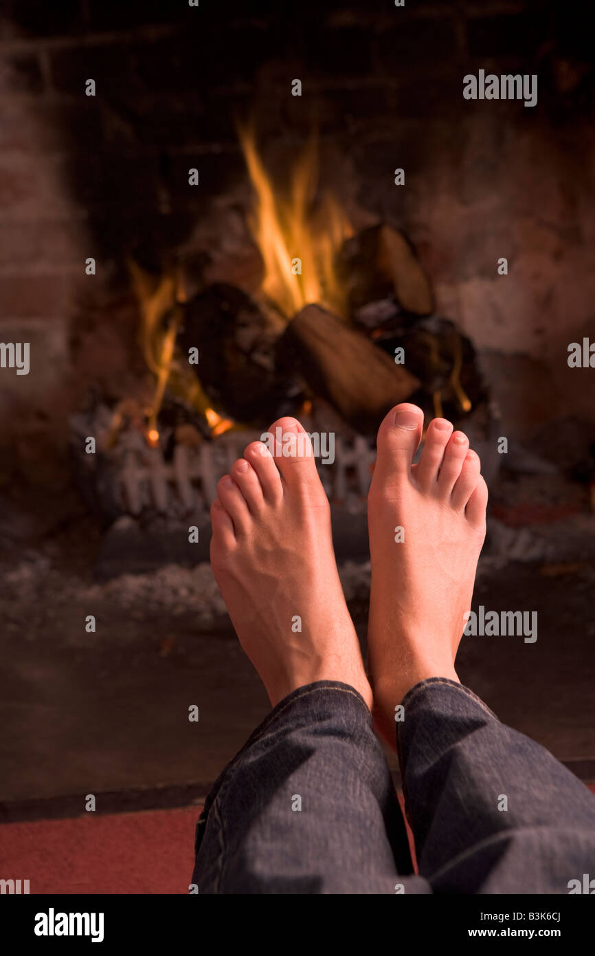 Feet warming at a fireplace Stock Photo - Alamy