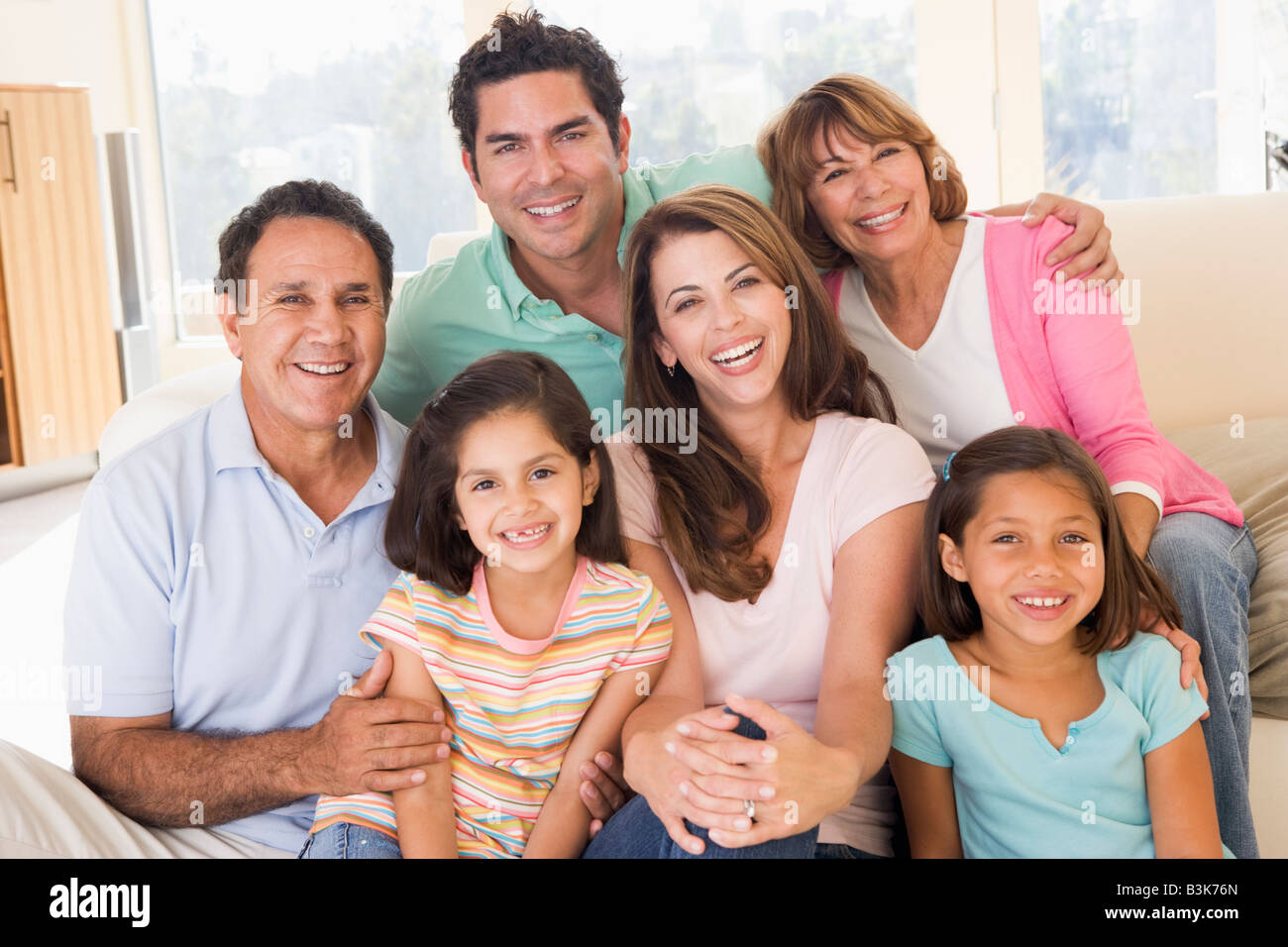 Extended family in living room smiling Stock Photo - Alamy