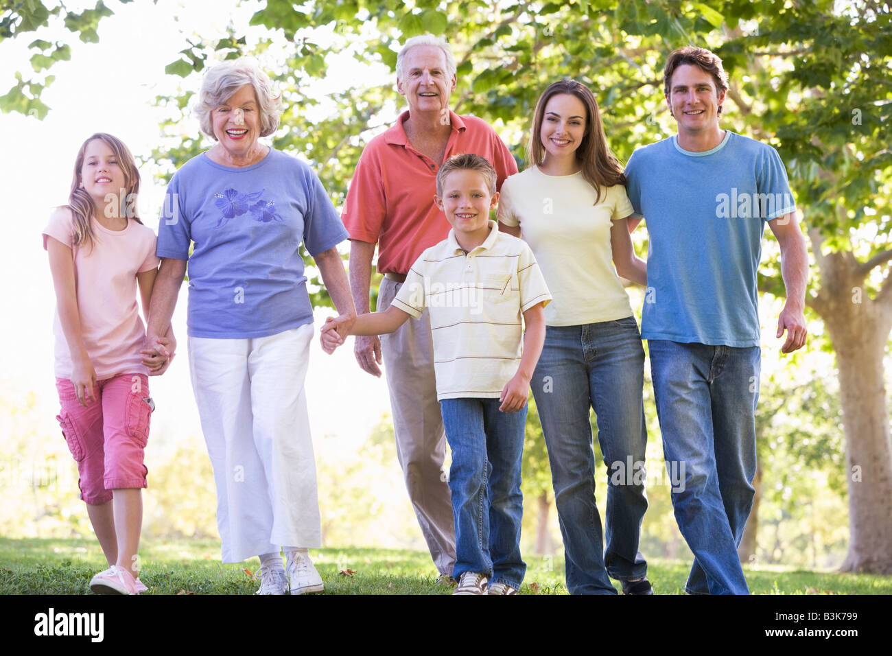 Extended family walking in park holding hands and smiling Stock Photo ...