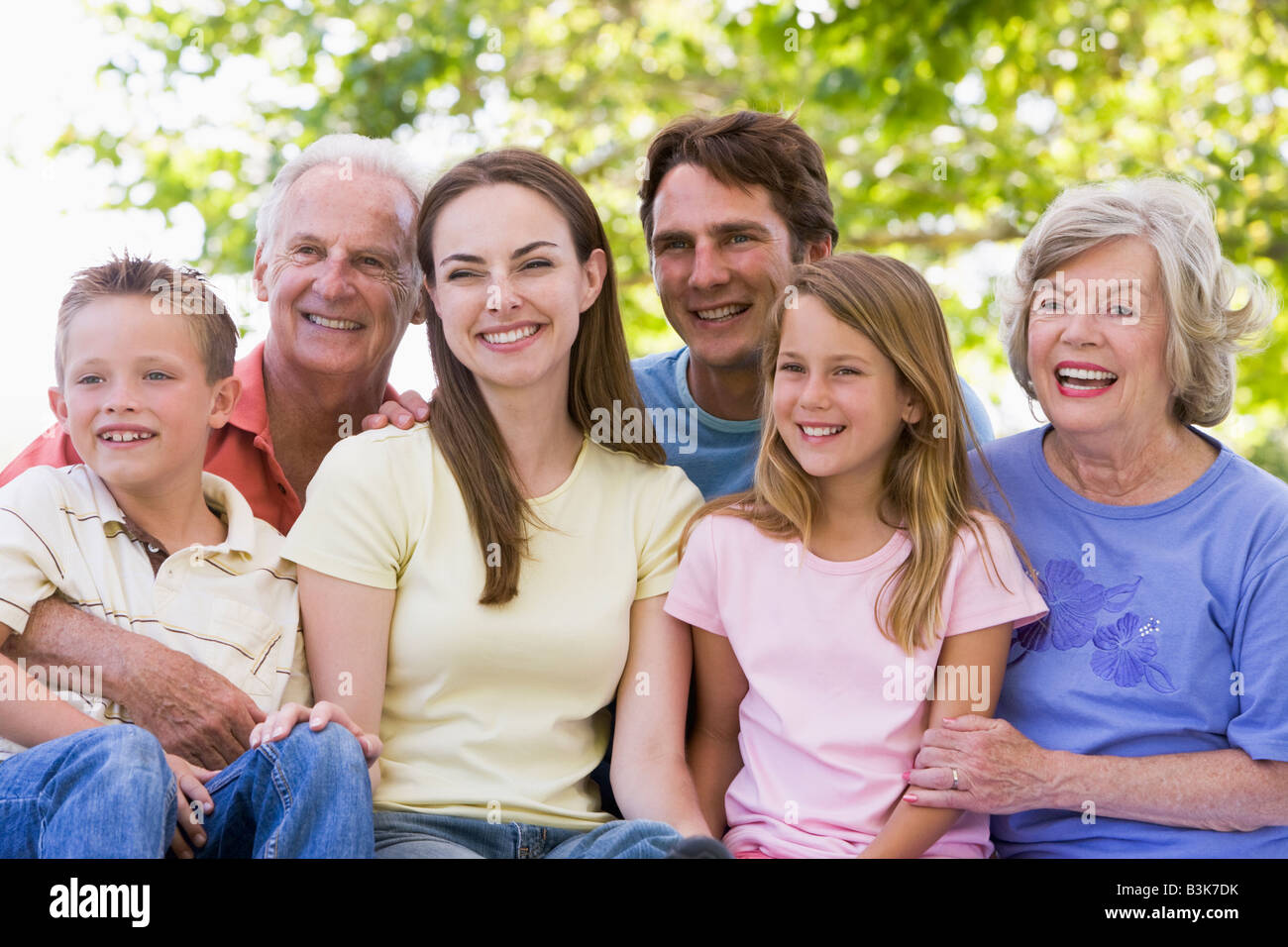 Extended family sitting outdoors smiling Stock Photo - Alamy