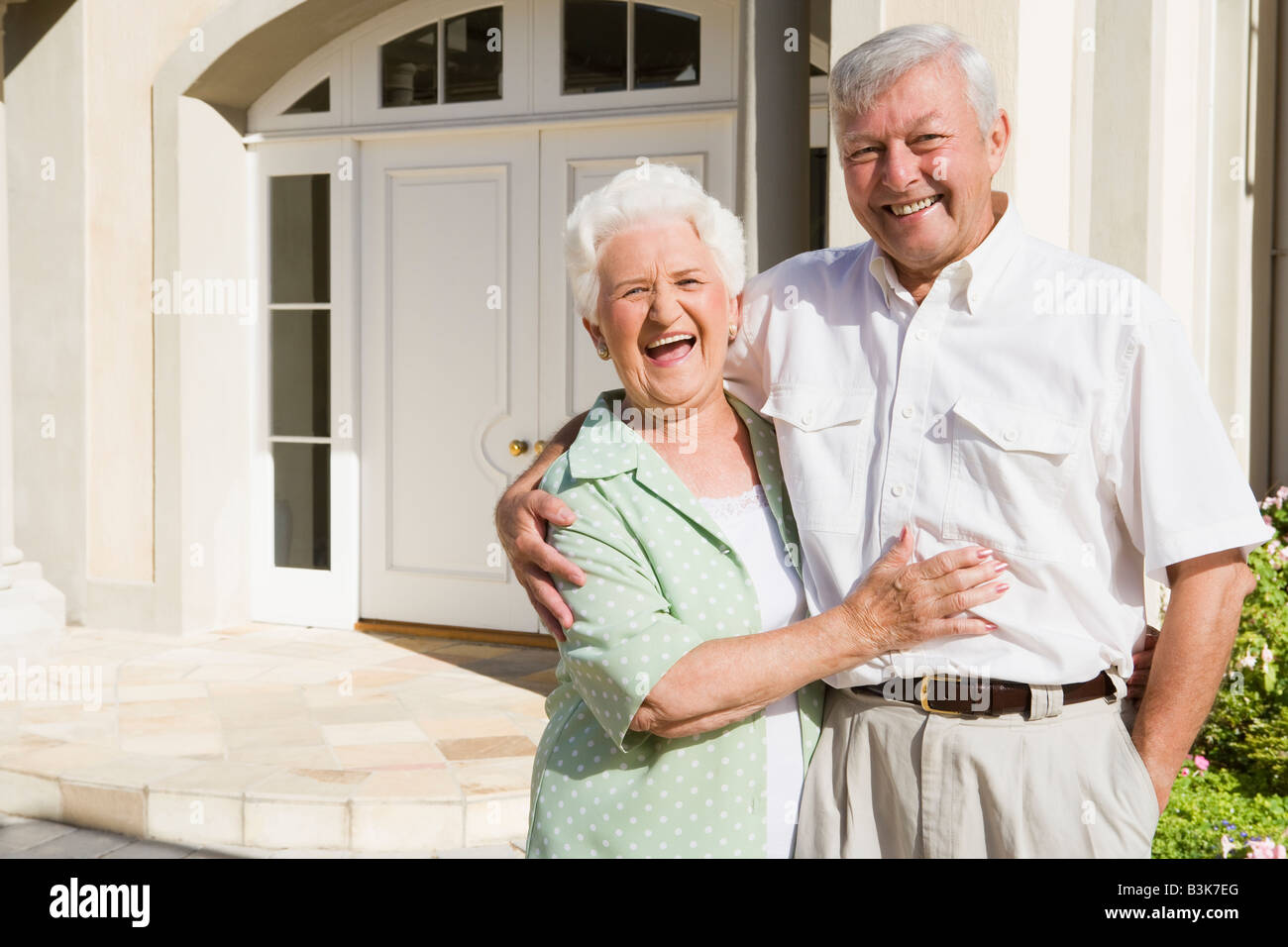 Senior couple standing outside their home Stock Photo - Alamy