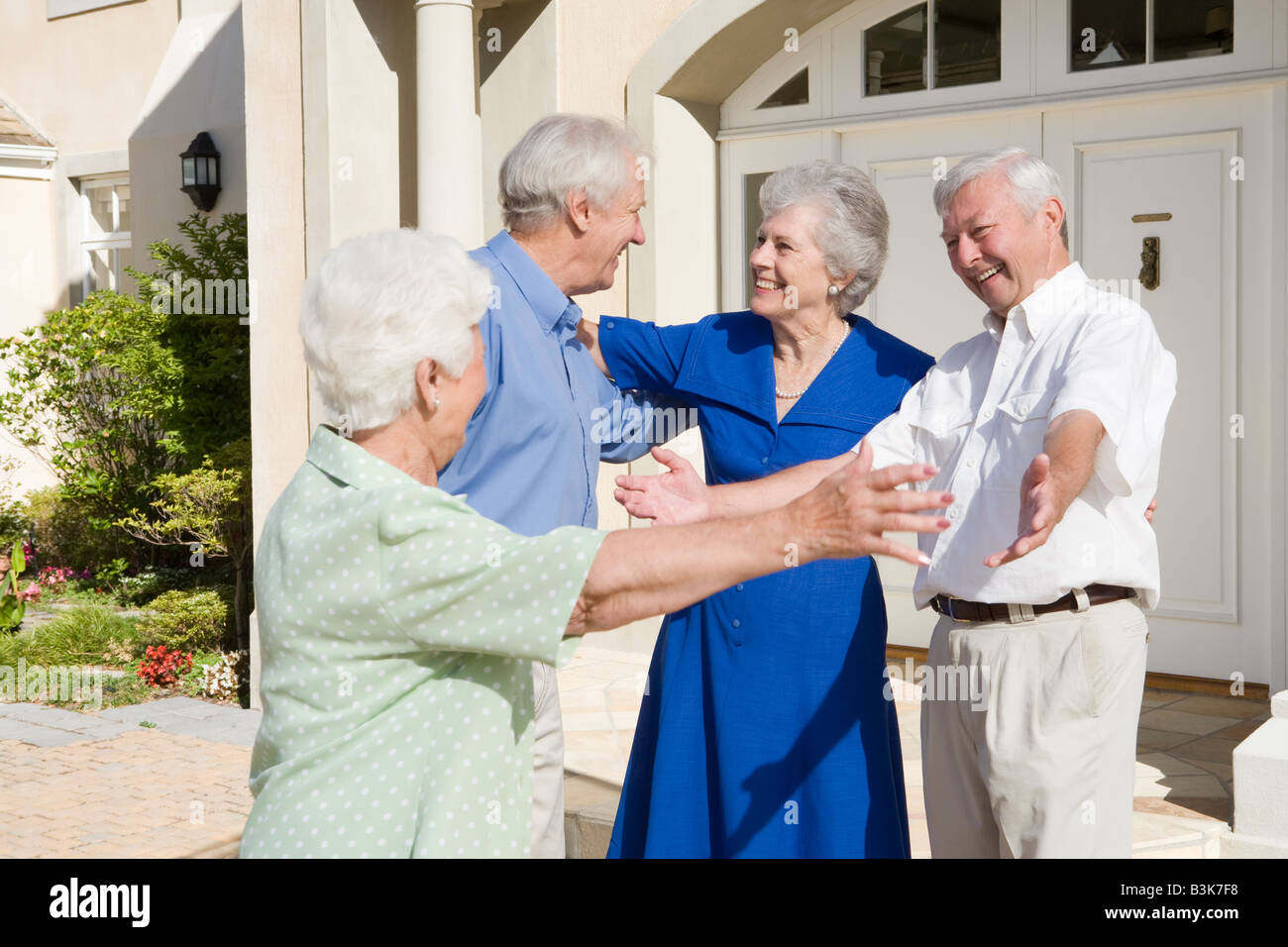 Two senior couples greeting each other with open arms Stock Photo - Alamy
