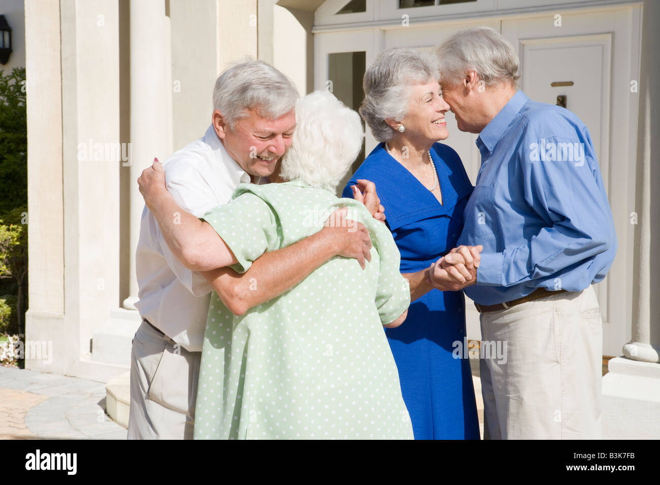 Two senior couples greeting each other with open arms Stock Photo - Alamy