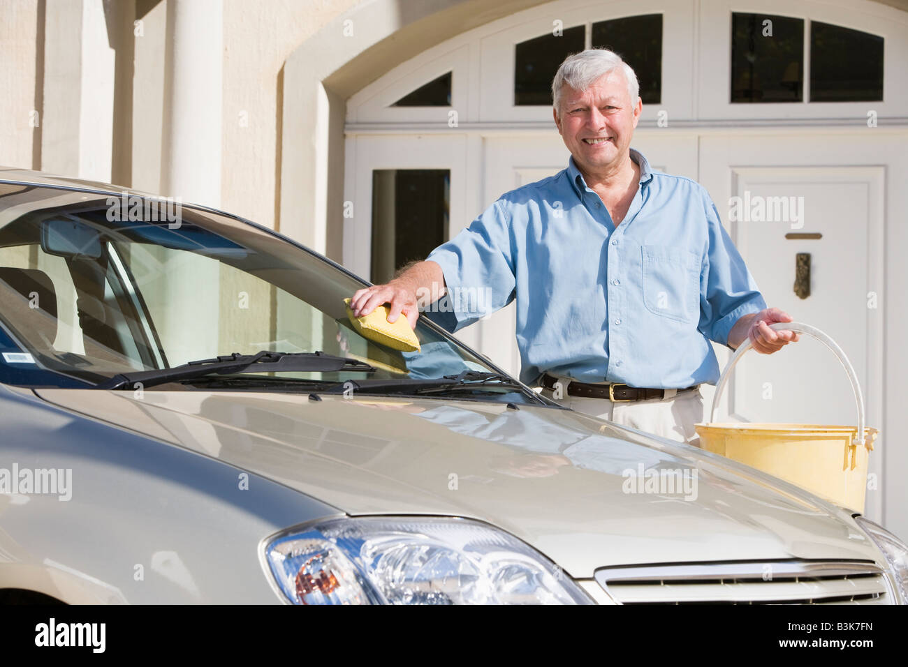 Senior man washing car outside his home Stock Photo - Alamy