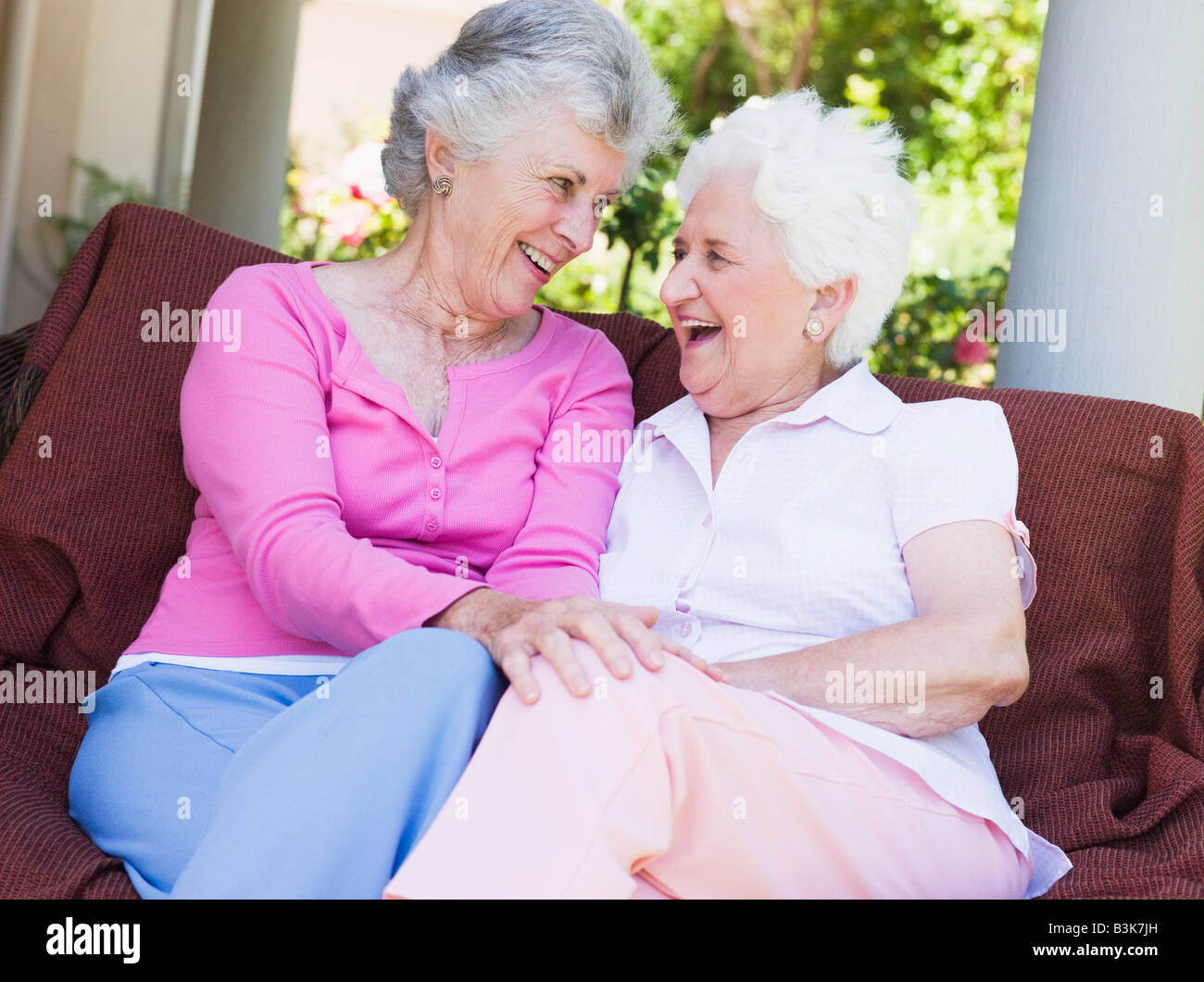 Two senior women sitting outdoors on a chair Stock Photo - Alamy