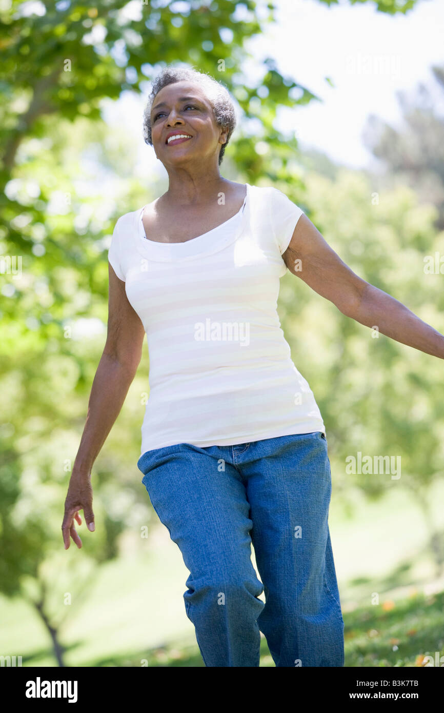 Senior woman walking in park Stock Photo - Alamy