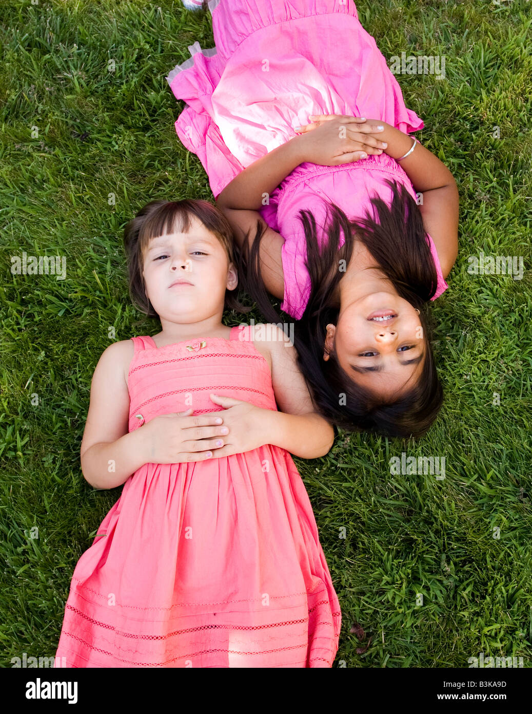 2 little girls lay in the grass Stock Photo - Alamy