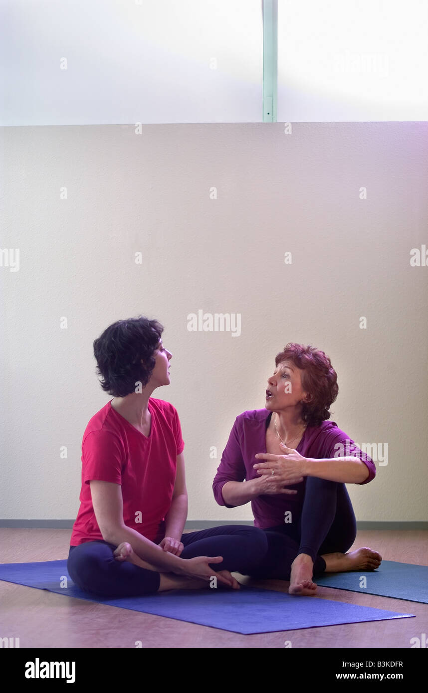 2 women having a conversation during yoga class Stock Photo - Alamy