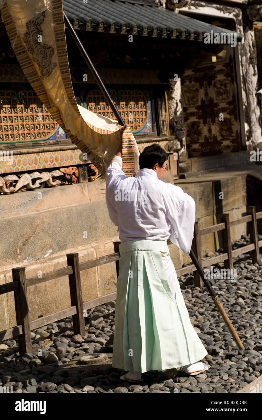 A Shinto priest attends to duties at the Toshogu Shrine in Nikko, Japan ...