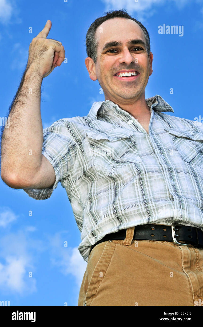 Happy middle aged man gesturing on blue sky background Stock Photo - Alamy