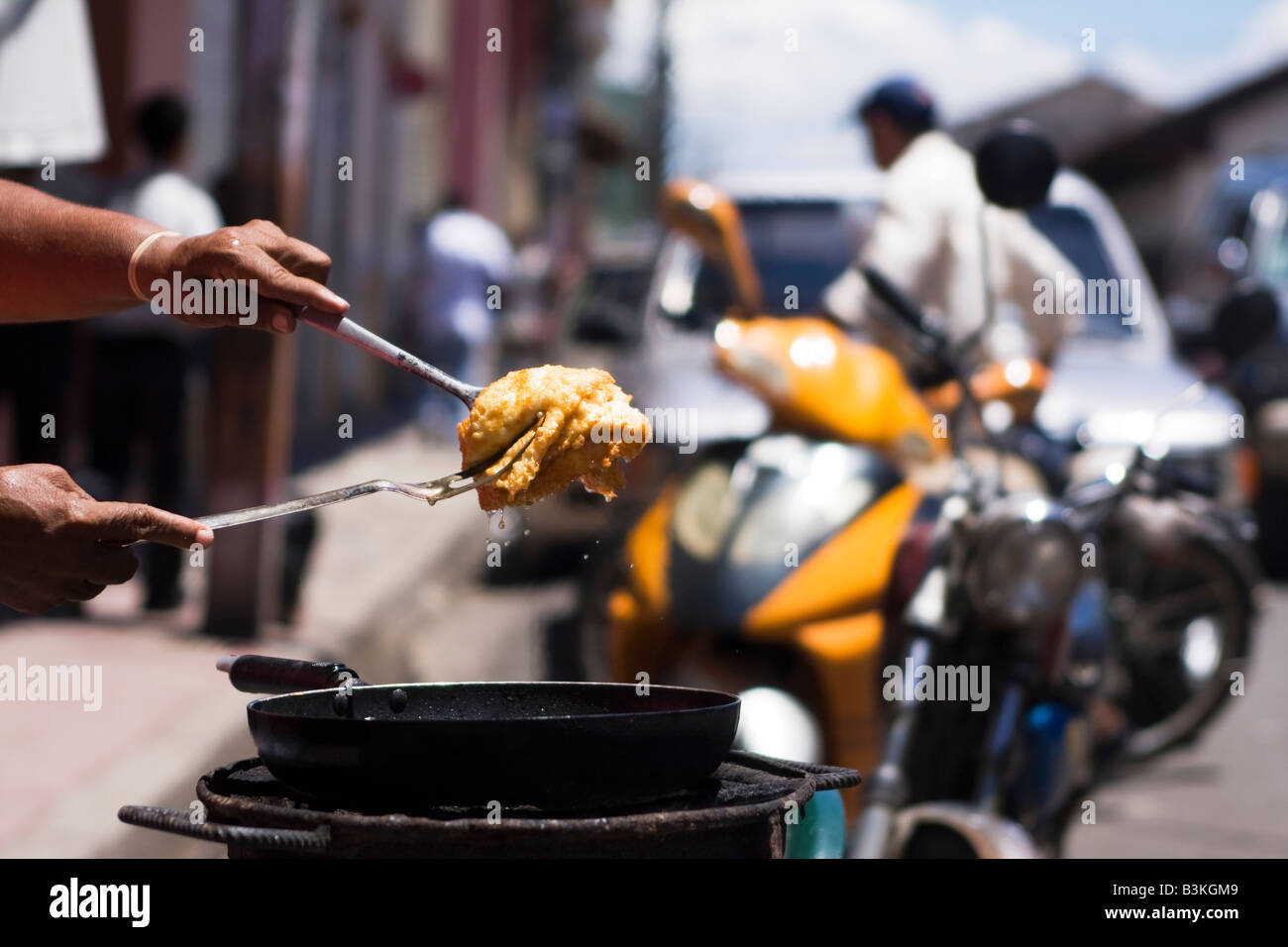 A woman cooking at a street stall She is cooking fried cheese bubbling ...