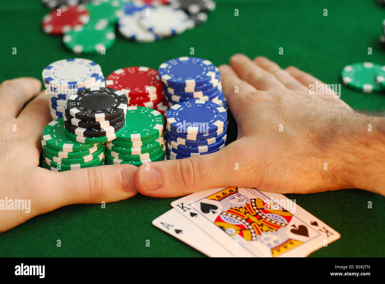 Poker player going all in pushing his chips forward Stock Photo - Alamy