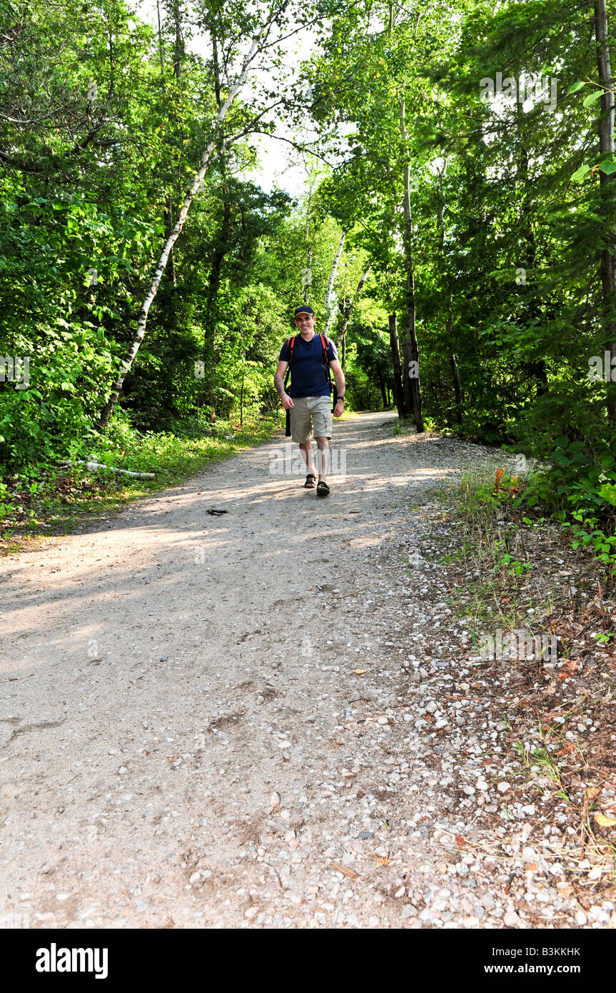 Happy middle aged man walking on a forest trail Stock Photo - Alamy