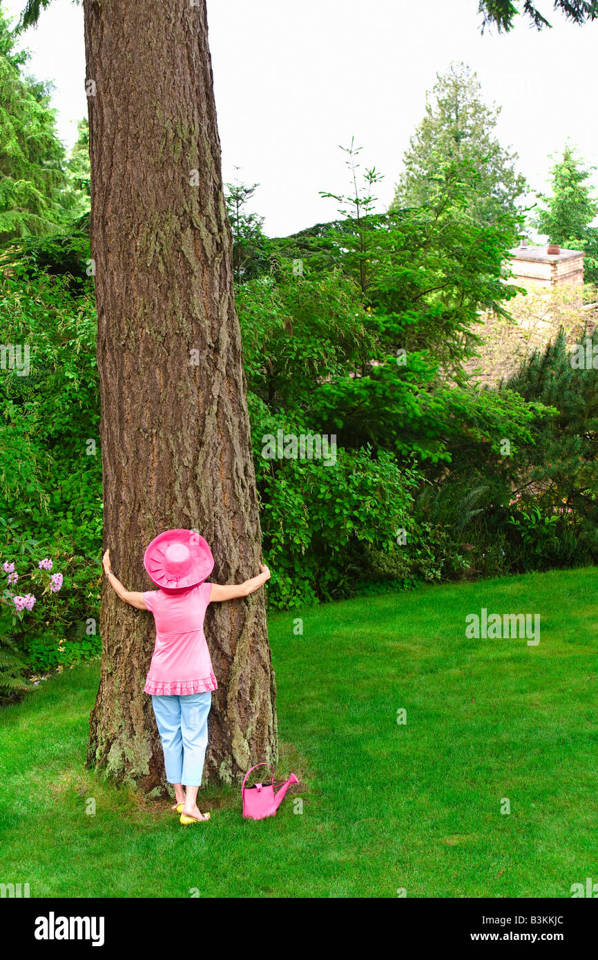 Woman in festive pink hat hugging tree Stock Photo - Alamy