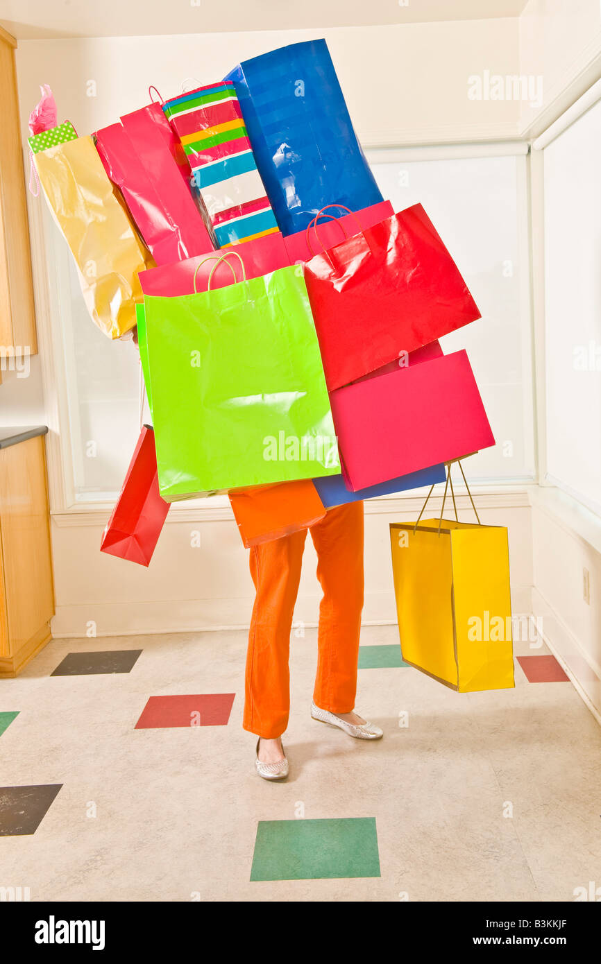 Woman balancing assorted shopping bags Stock Photo - Alamy