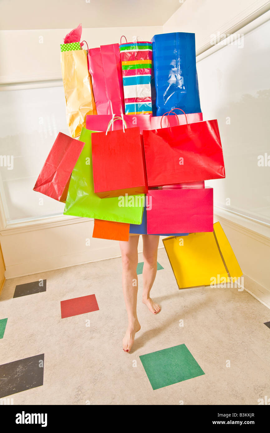 Woman balancing assorted shopping bags Stock Photo - Alamy