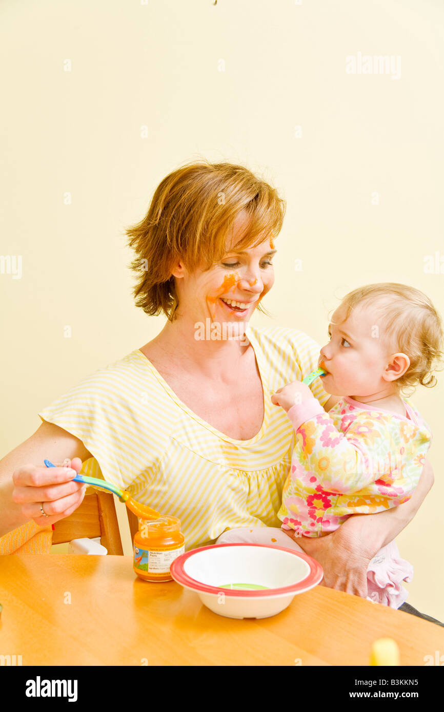 Mother feeding messy baby Stock Photo - Alamy