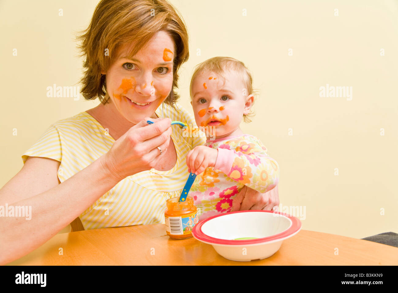 Mother feeding messy baby Stock Photo - Alamy