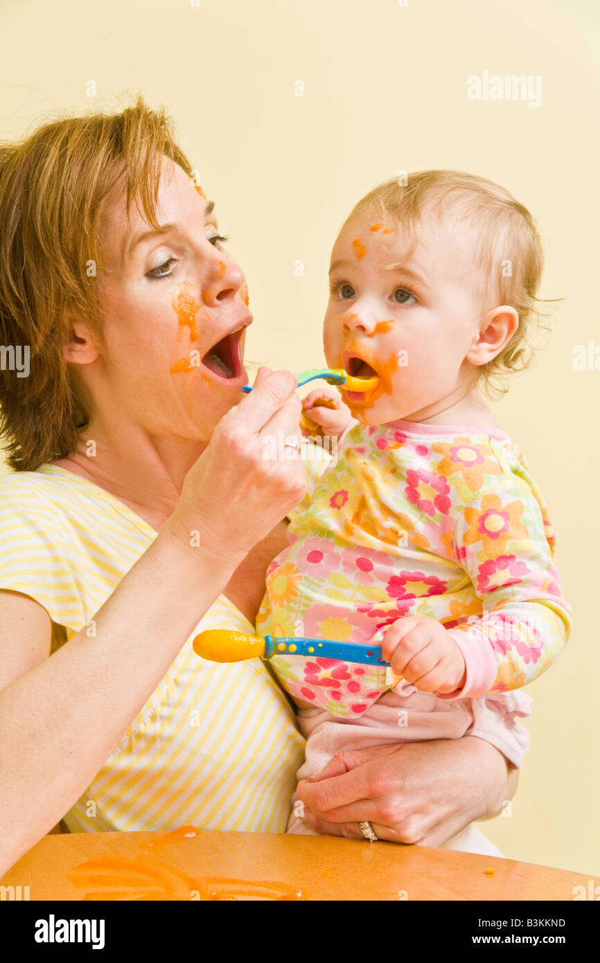 Mother feeding messy baby Stock Photo - Alamy