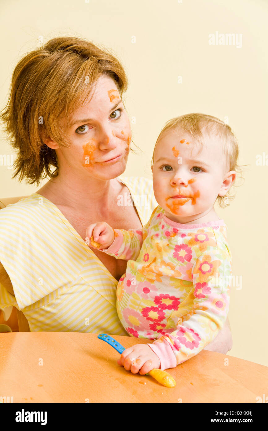 Frustrated mother feeding messy baby Stock Photo - Alamy