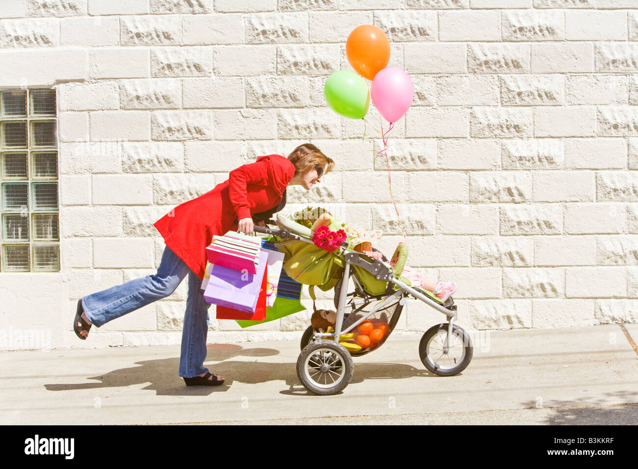 Woman pushing baby girl in stroller Stock Photo - Alamy
