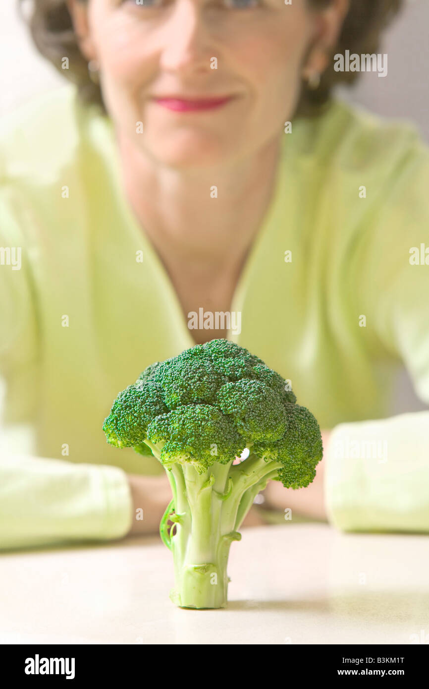 Woman looking at broccoli Stock Photo - Alamy