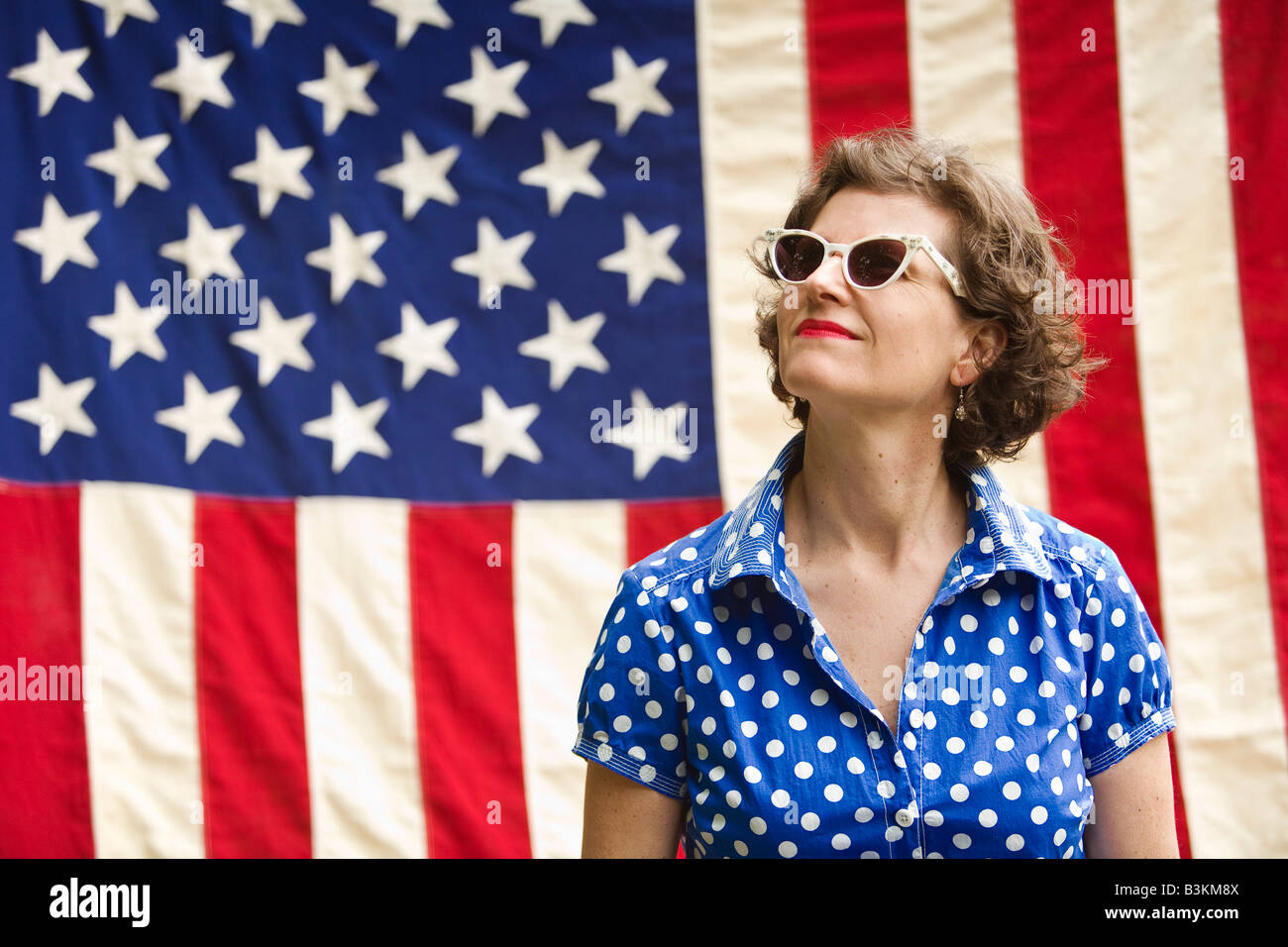 Patriotic woman posing with American flag Stock Photo - Alamy